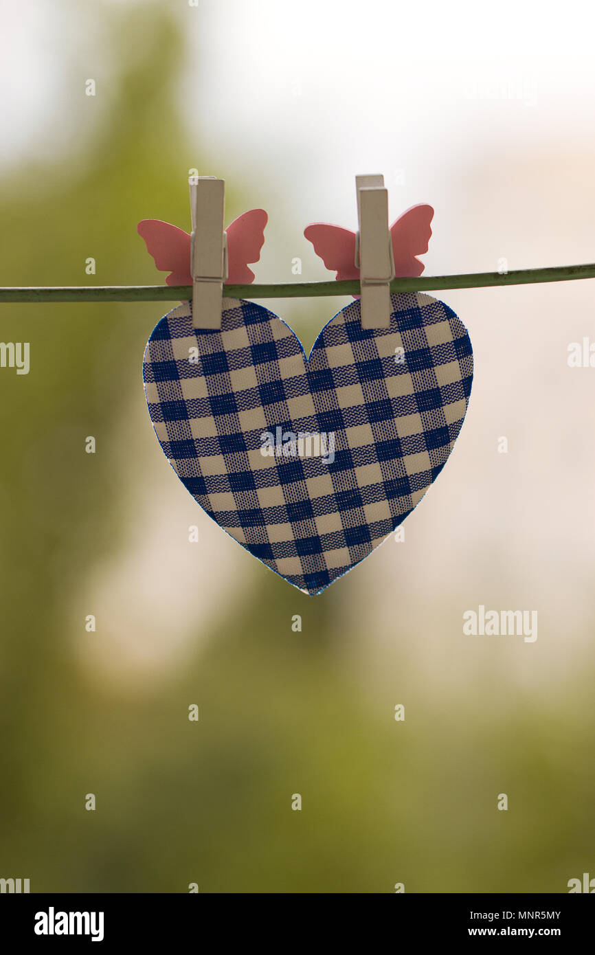 blue heart attached to a clothesline with pin Stock Photo - Alamy