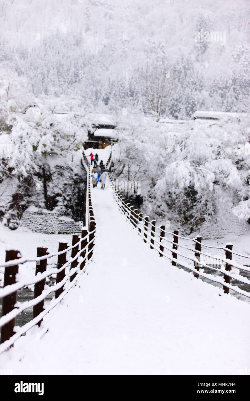 People crossing the bridge over Shogawa river at historic Japanese ...