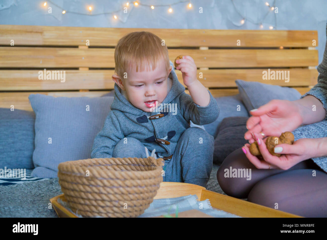 Happy young mother and her baby son playing with walnuts Stock Photo ...