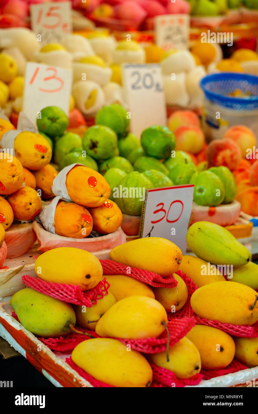 Assortment of fresh mangoes and other fruits on market stall Stock ...