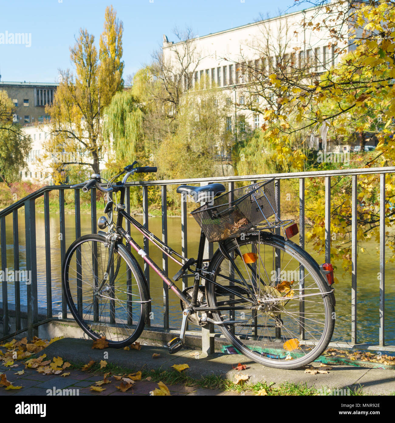 A bicycle attached to the railing of the bridge across the river Isar ...