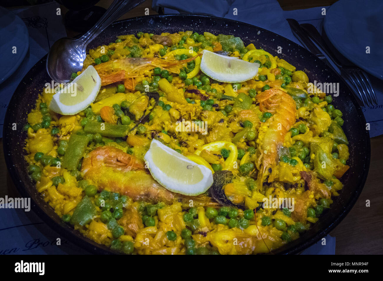 Gigantic paella dish with shrimps and lemon slices in a restaurant in ...