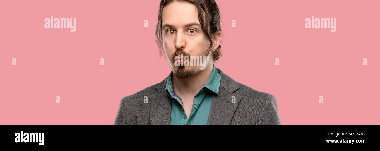 Handsome young man puffing out cheeks, having fun making funny face ...