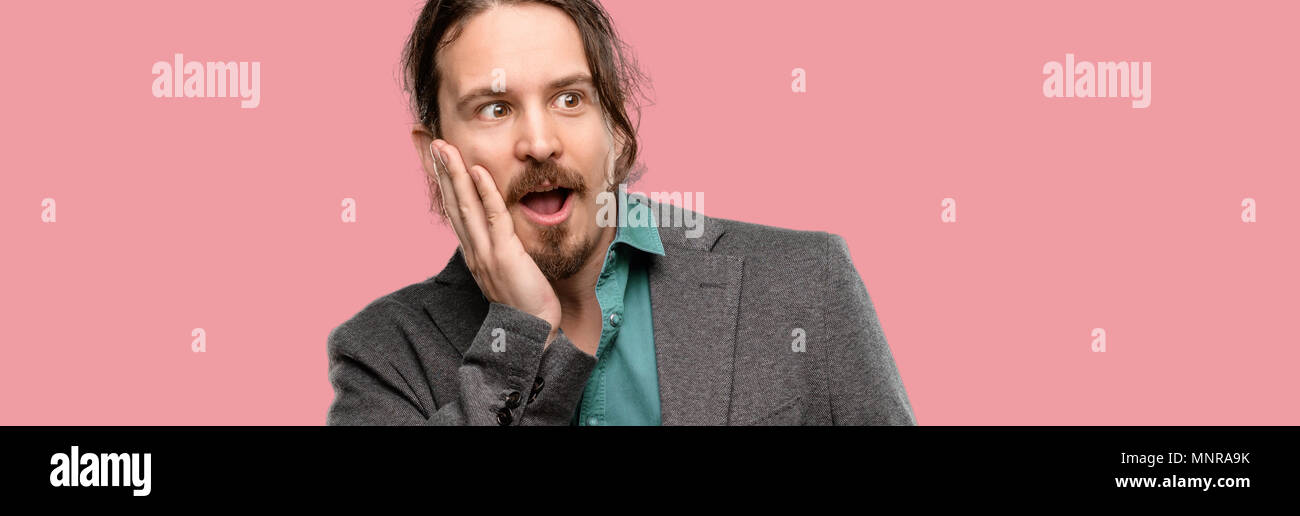 Handsome young man so happy and confident showing a big smile surprised ...