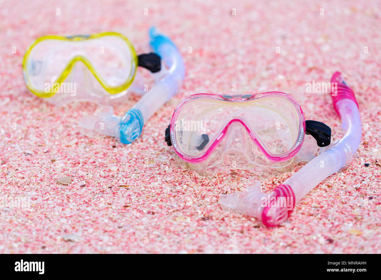 Snorkeling equipment mask and snorkel on beach made of small pink ...