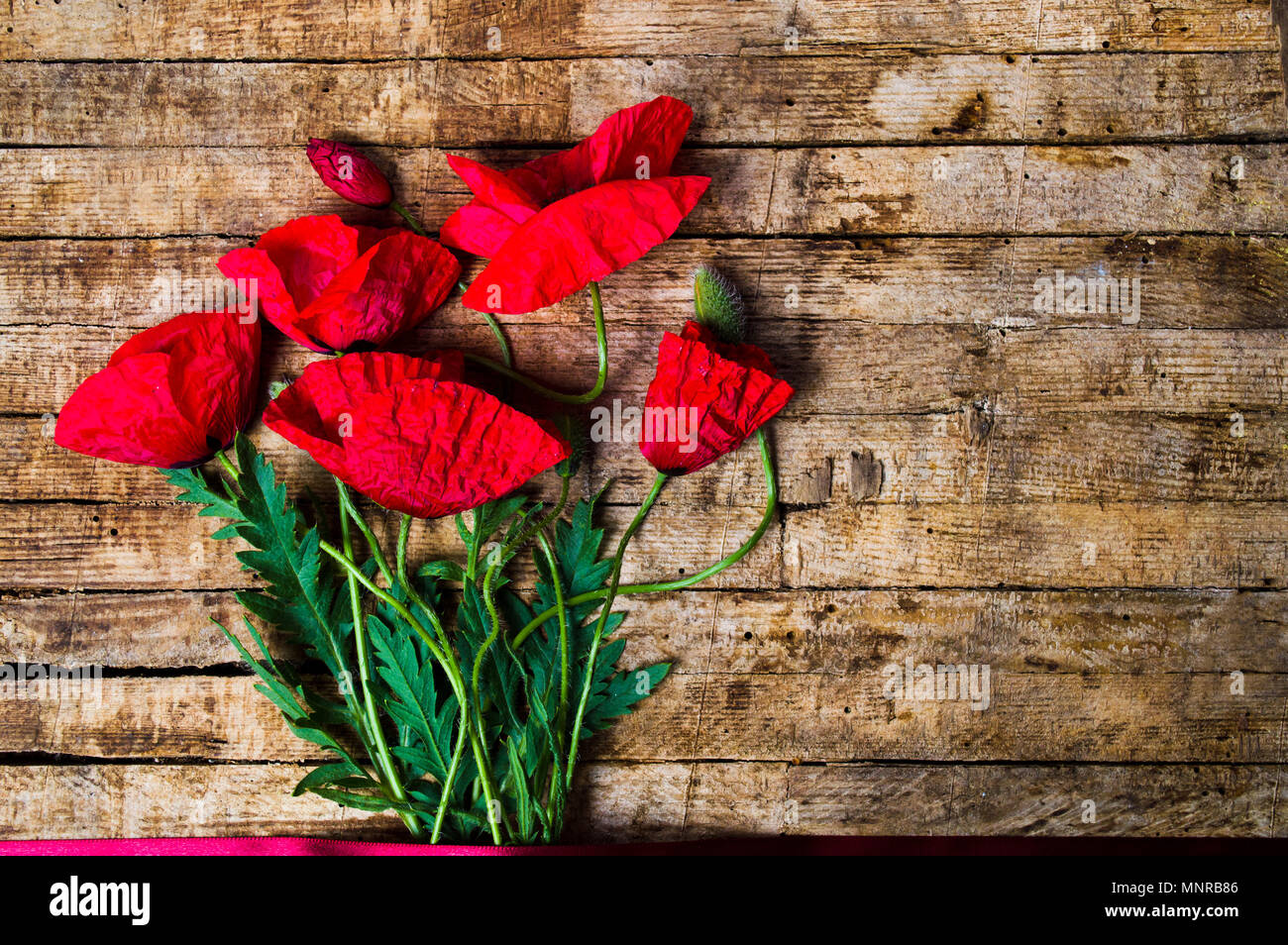 Poppy flowers on a wooden table top view Stock Photo - Alamy