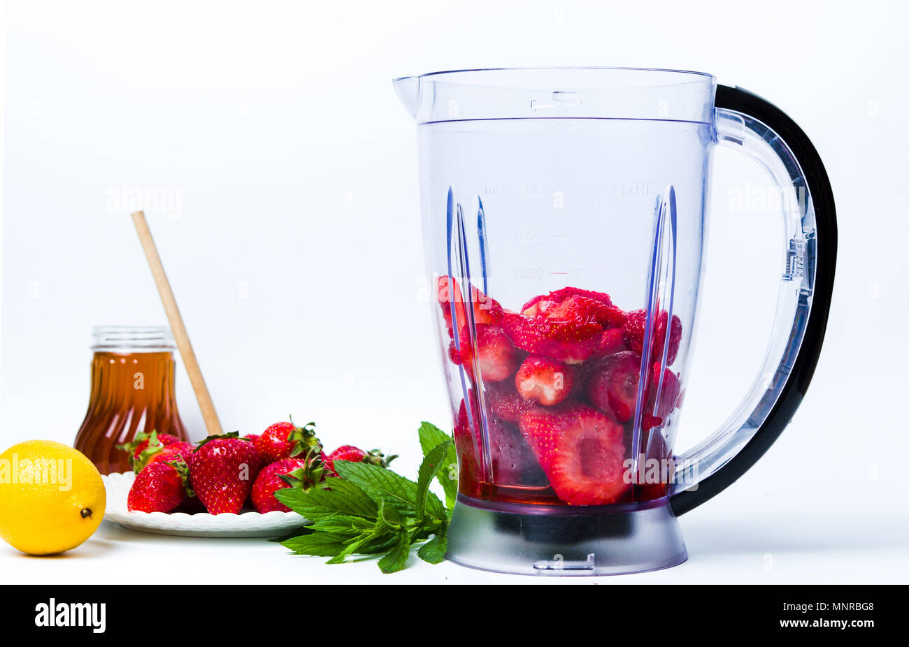 Strawberry smoothie ingredients in a blender isolated Stock Photo - Alamy