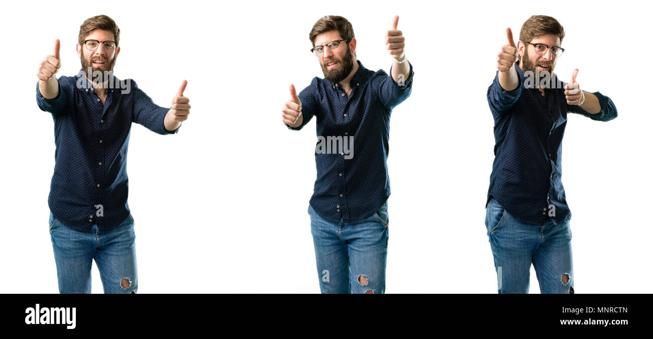 Young man with beard stand happy and positive with thumbs up approving ...