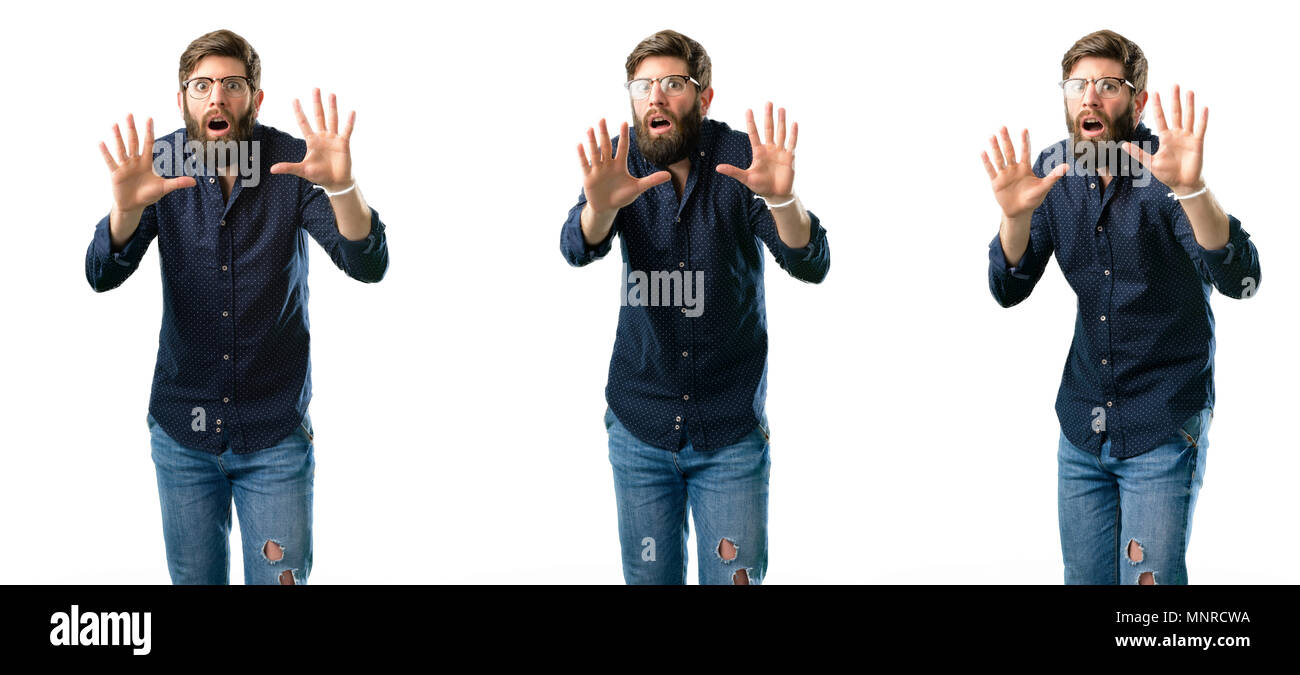 Young man with beard disgusted and angry, keeping hands in stop gesture ...