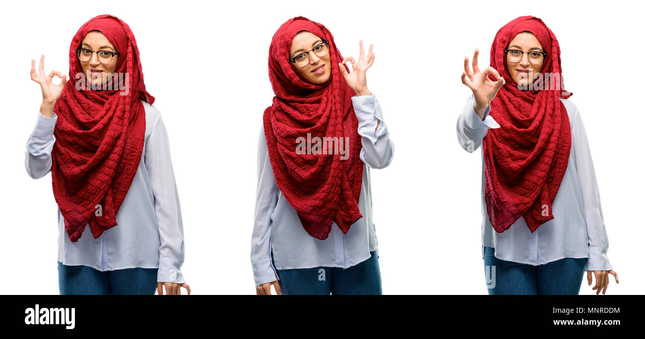 Arab woman wearing hijab doing ok sign with hand, approve gesture ...