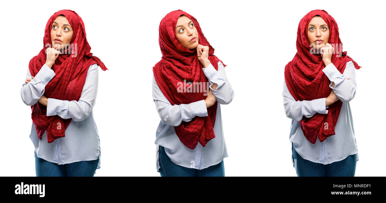 Arab woman wearing hijab thinking and looking up expressing doubt and ...