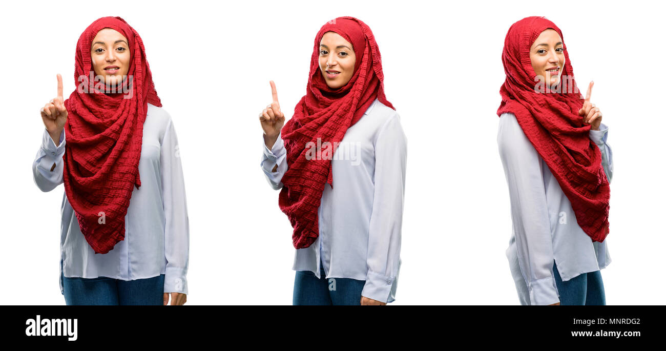 Arab woman wearing hijab raising his finger, the number one isolated ...