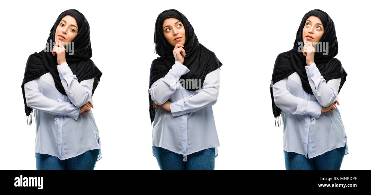 Arab woman wearing hijab thinking and looking up expressing doubt and ...