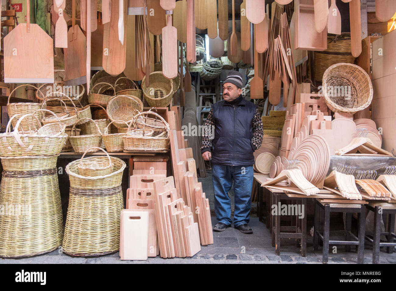 Adult male merchant stands with his hands in his pockets in entryway to ...