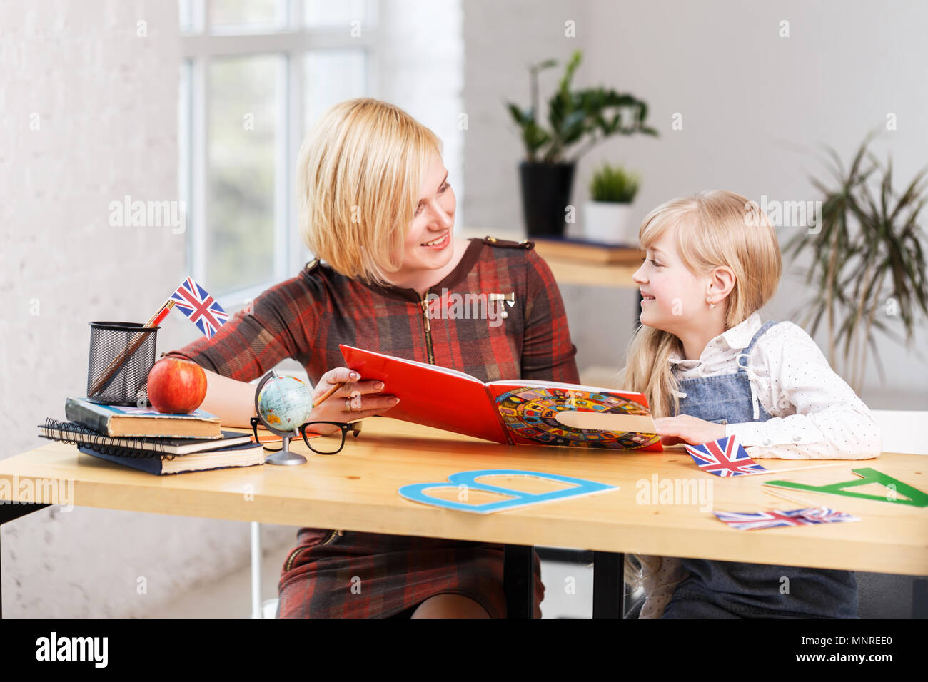 Pretty blonde english teacher work with smart kid girl, language ...