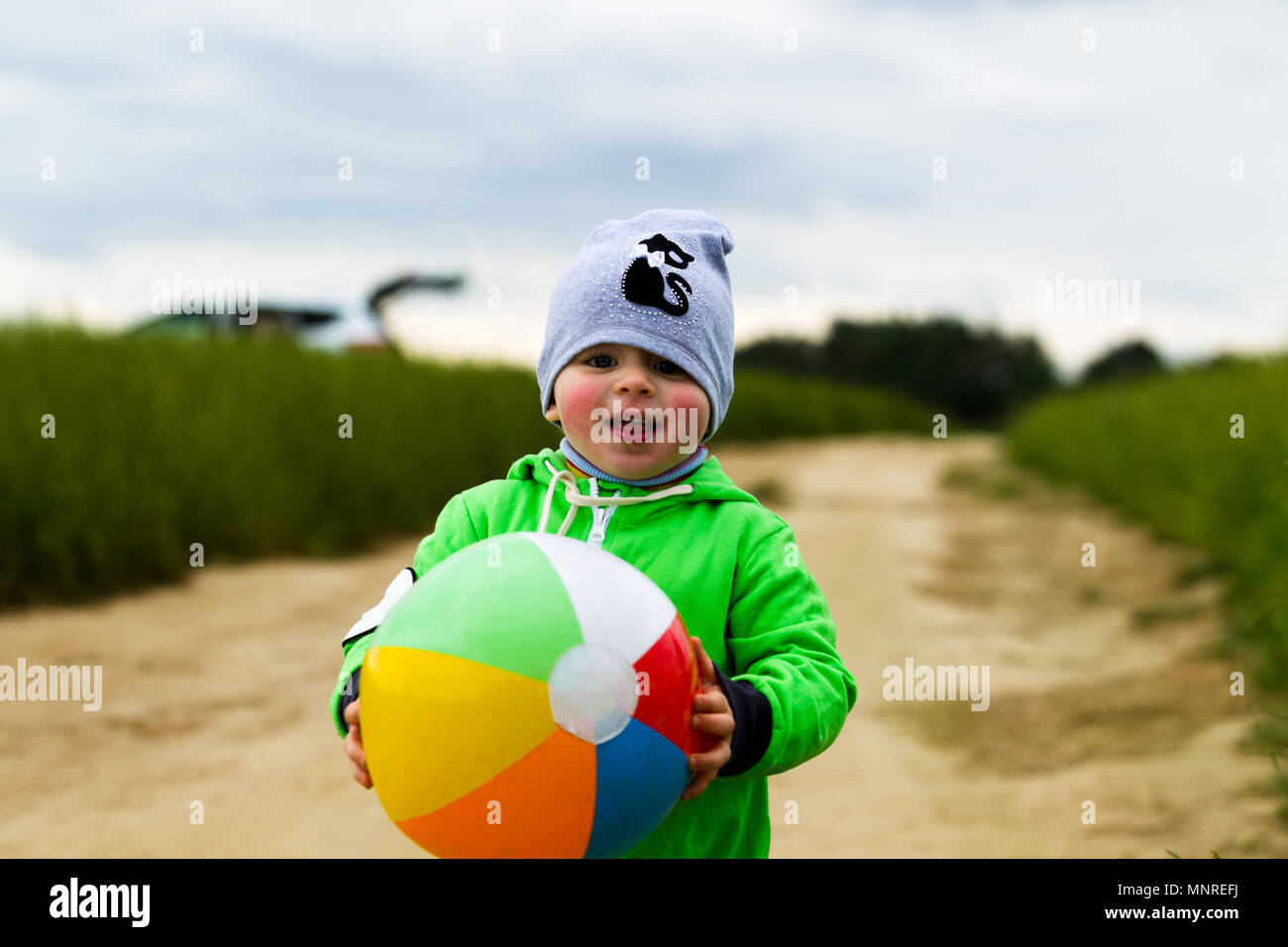 Small child with ball for a walk in the field Stock Photo - Alamy