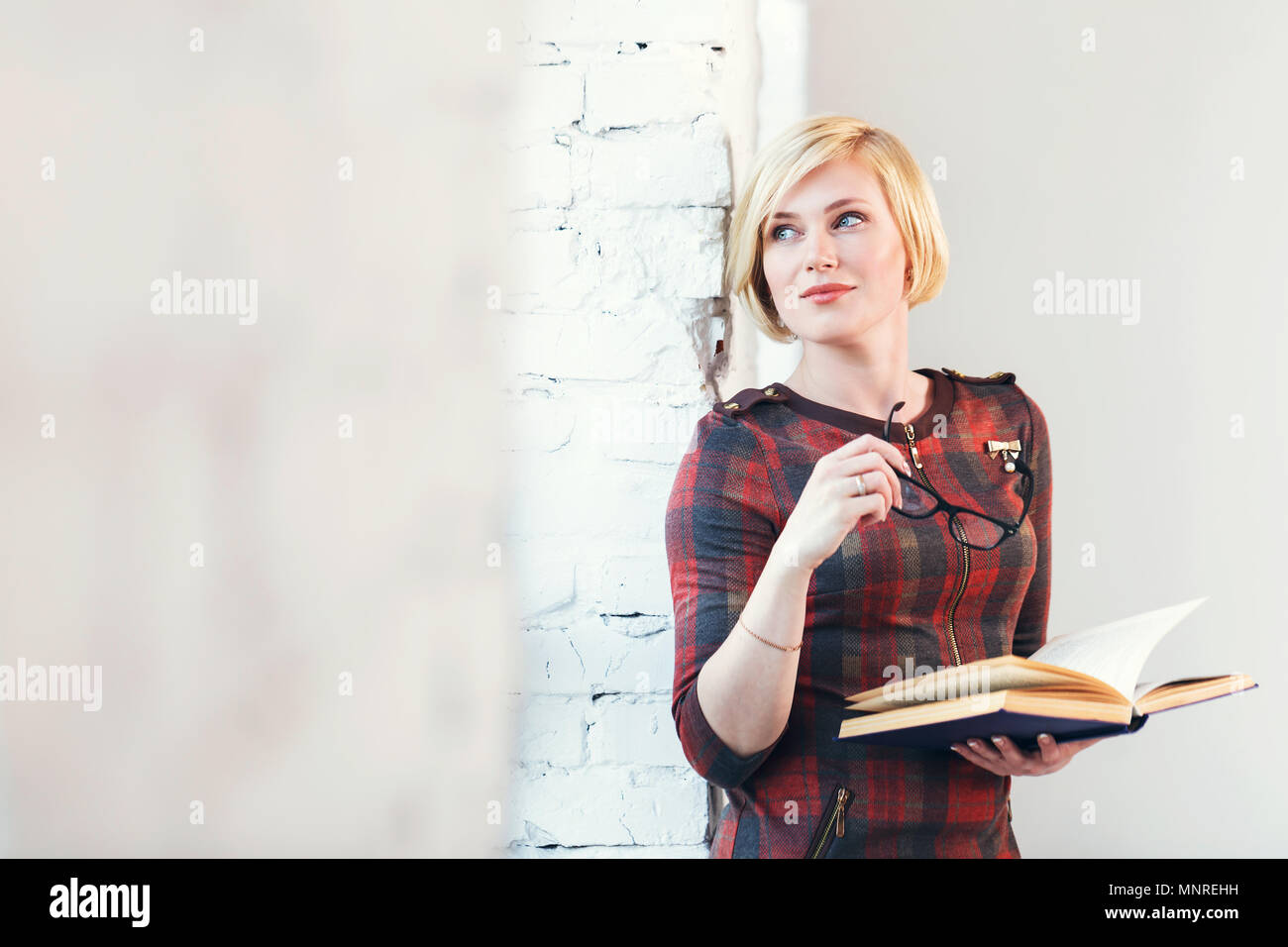 Pretty Intelligent Blonde Woman Wears Eyeglasses And Red Dress Reading