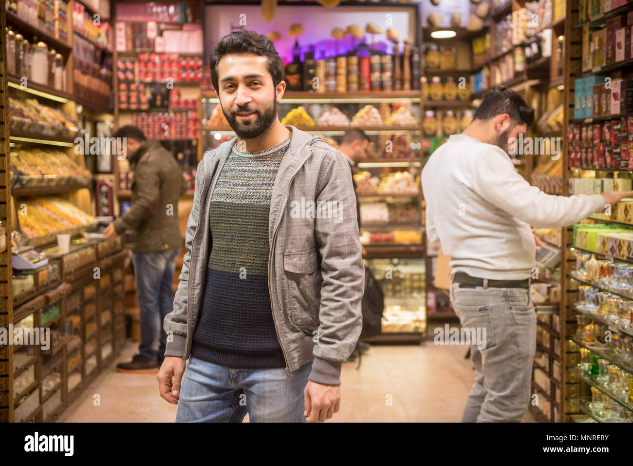 An adult male merchant smiles for photo in front of spice shop in ...