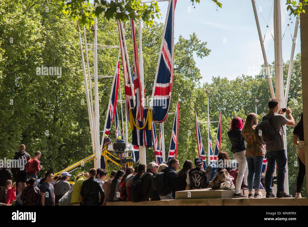A crowd of people with phones take selfies and pictures of an event at ...