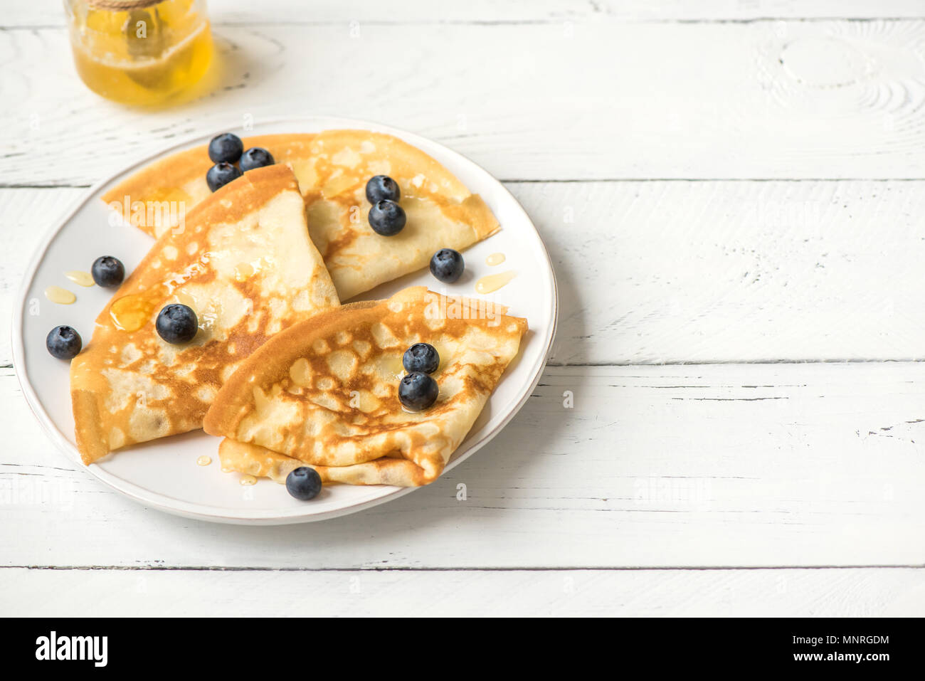 Crepes with blueberries and honey. Homemade pancakes, crepes on white ...