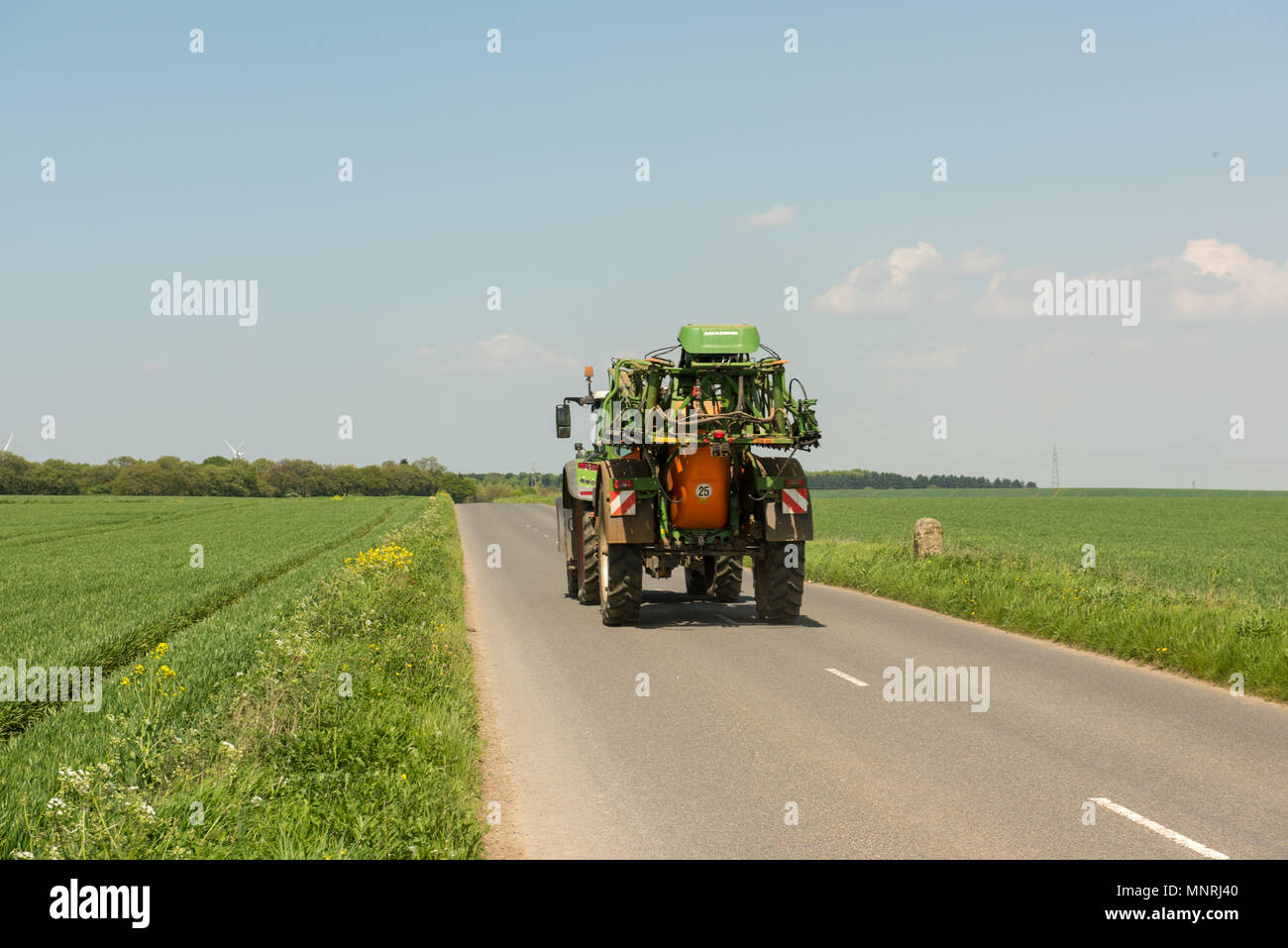 A tractor driving down a country road through green fields in South ...