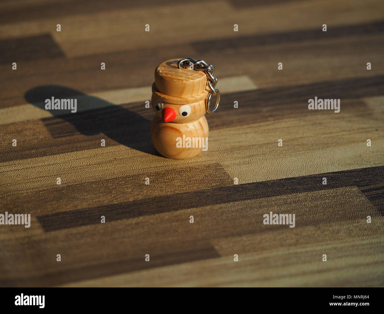 Little key-chain toy with eyes and nose standing on a flat surface with ...