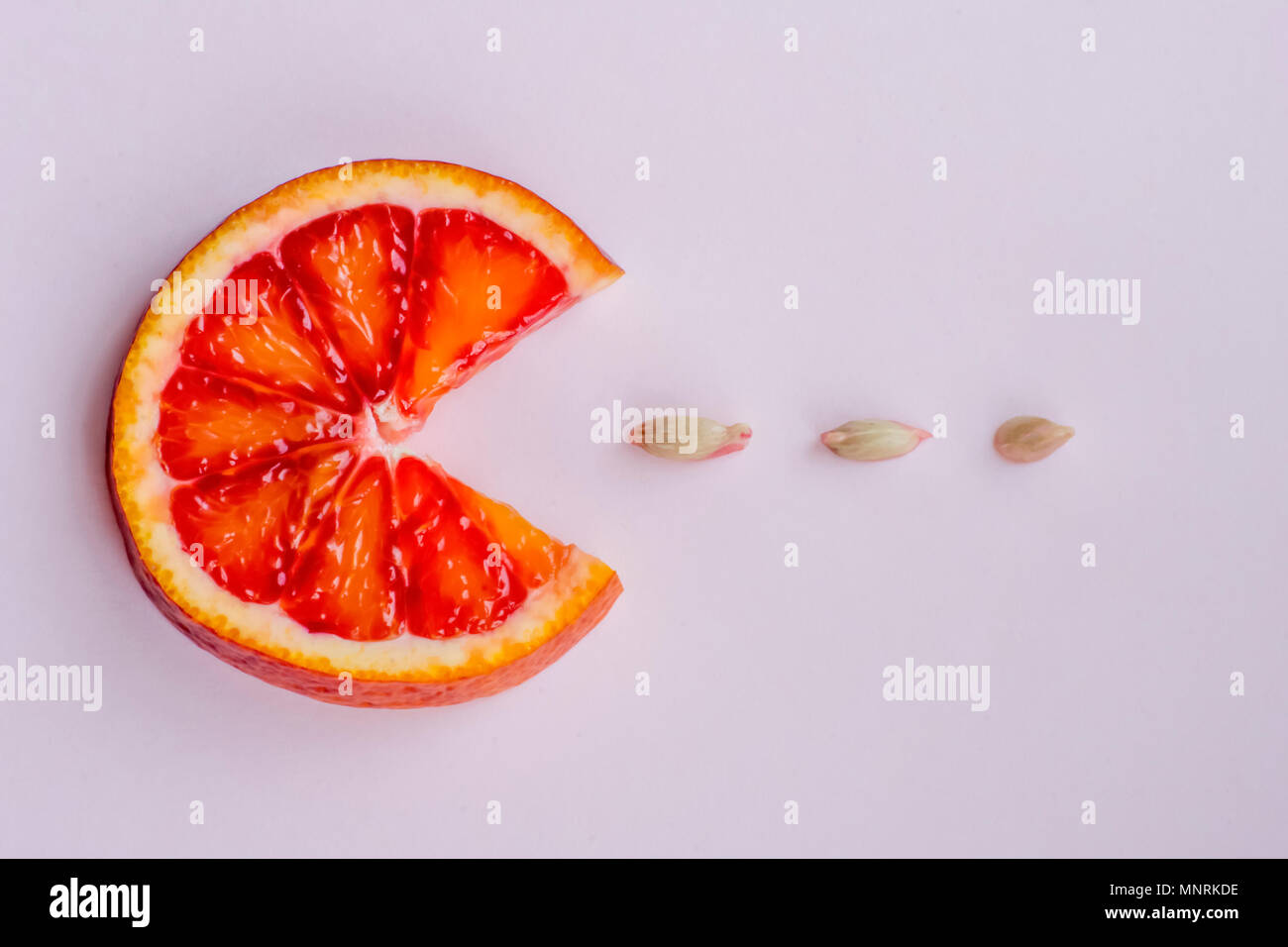 a round slice of red orange, three seeds Stock Photo - Alamy