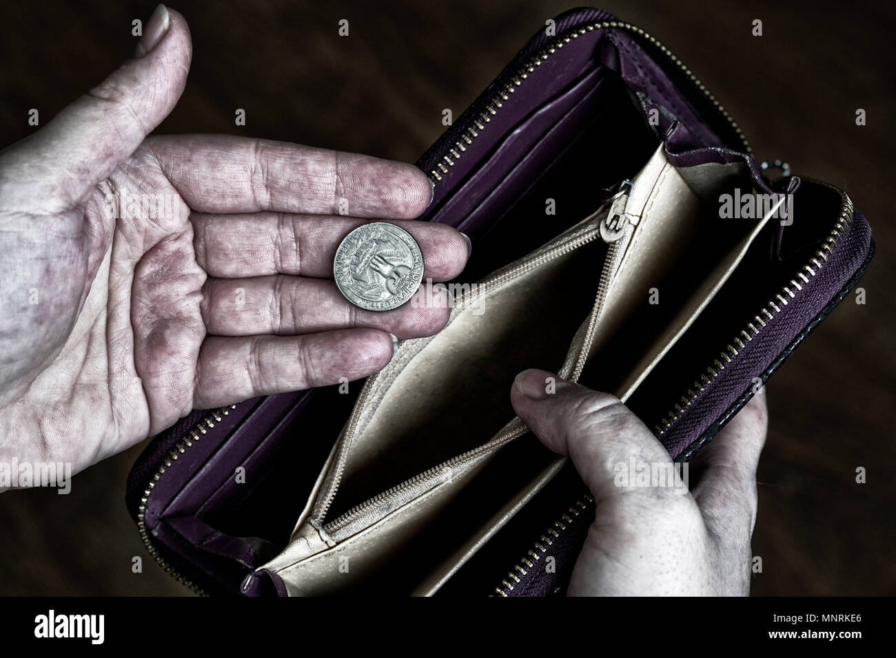 The dirty hands of the poor man hold one quarter of a dollar and an ...