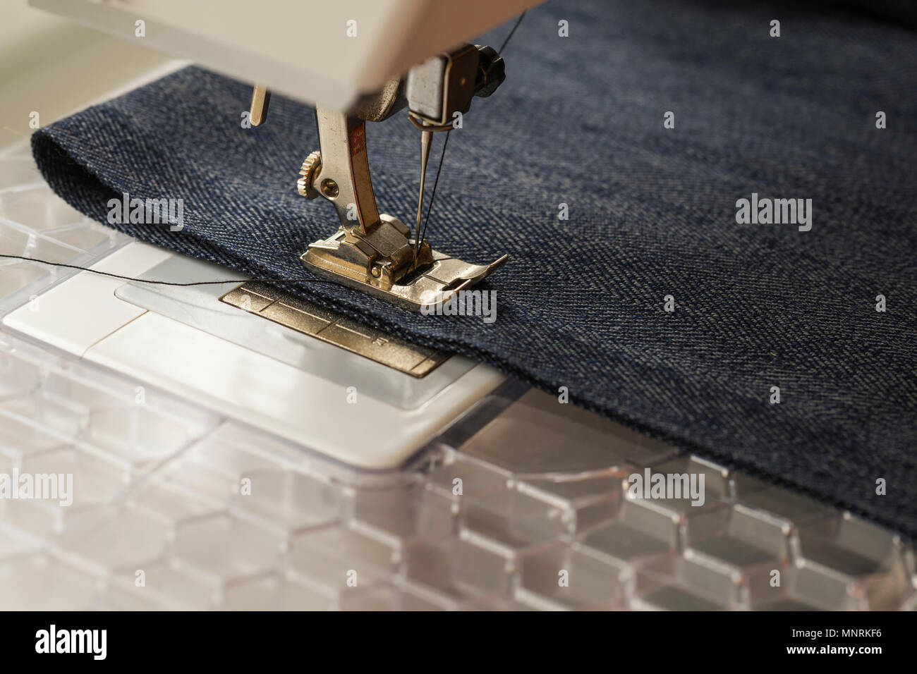 sewing machine sews denim fabric Stock Photo - Alamy