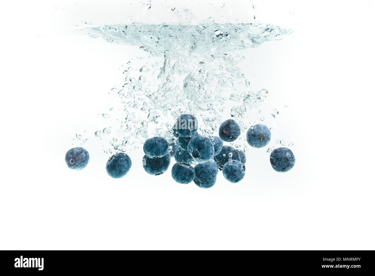Blueberries sinking into water with air bubbles white background Stock ...