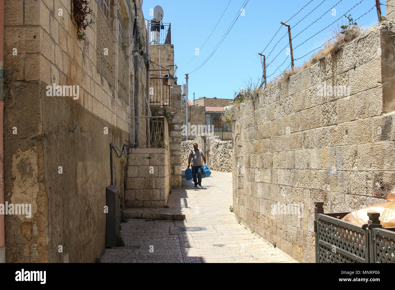 Jerusalem, Israel - May 16, 2018: A man carries garbage bags through ...