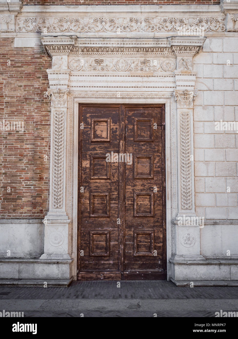 Old wooden portal with columns and architrave in white stone carved ...