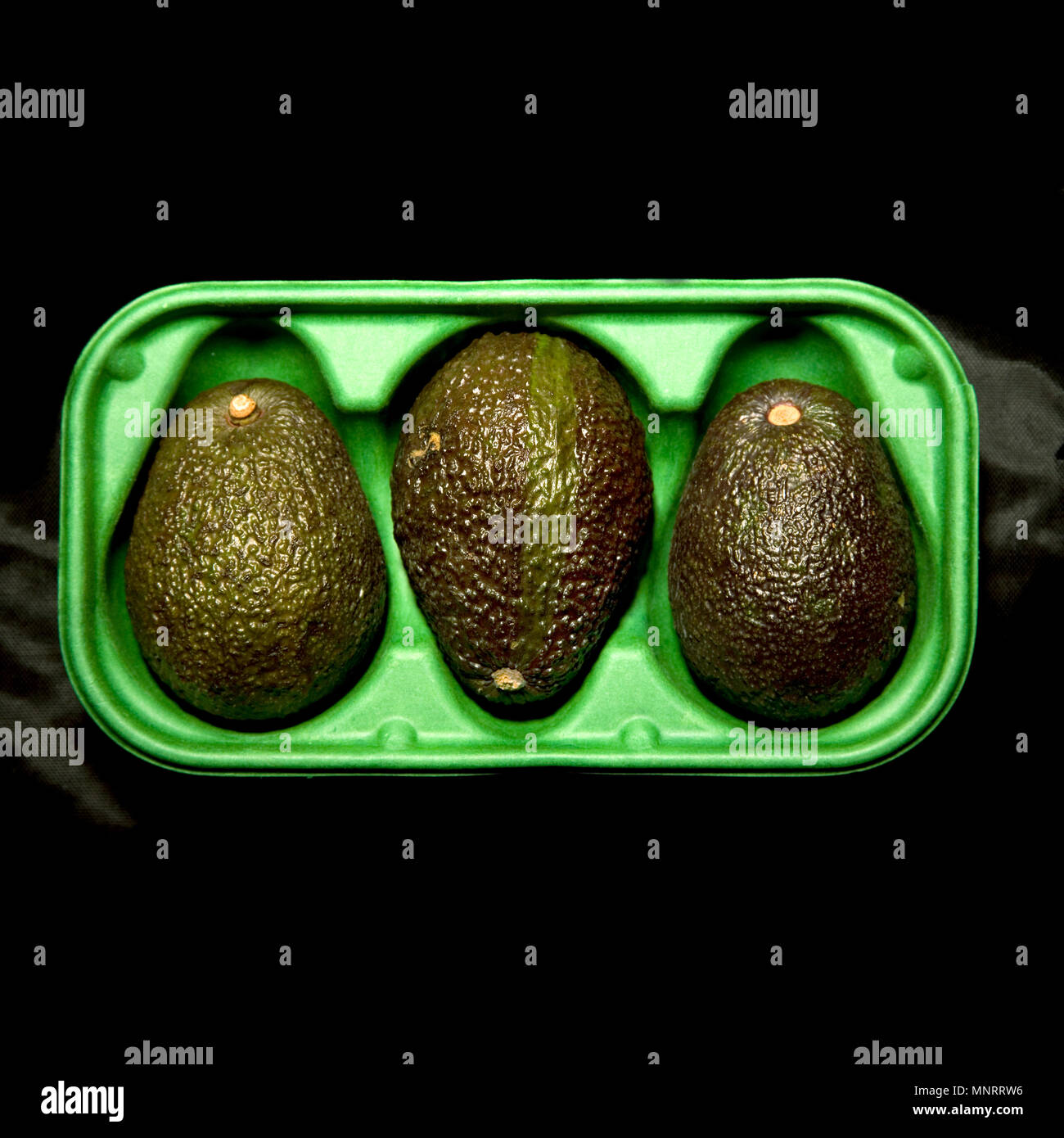 three avocados in a green box Stock Photo - Alamy