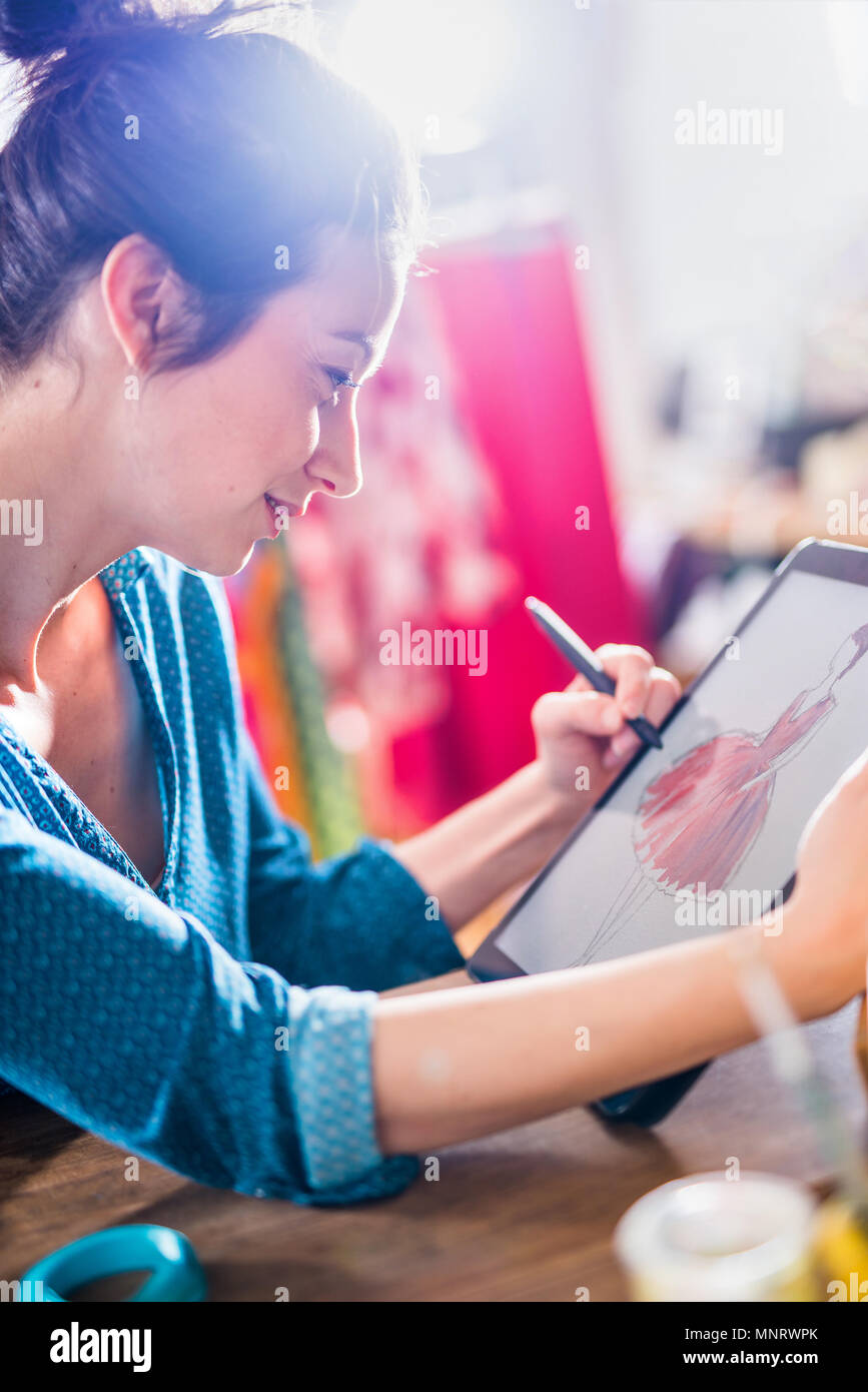 Fashion designer drawing a new model on a digital tablet Stock Photo ...