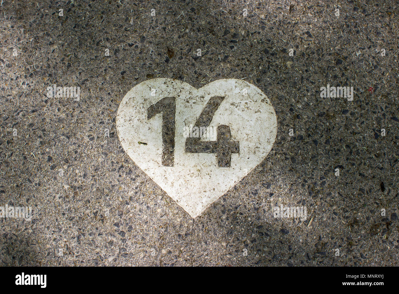 Digit 14 painted in white heart on a pavement Stock Photo - Alamy