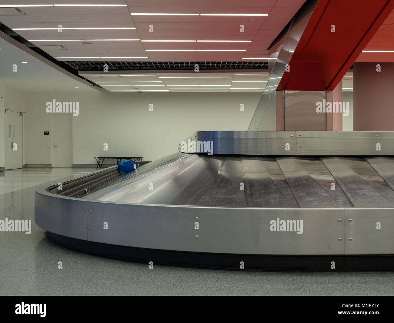 Lone piece of luggage sitting on baggage claim carousel in airport ...