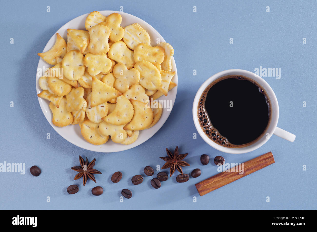 Crackers in plate and cup of coffee on blue table, top view Stock Photo ...