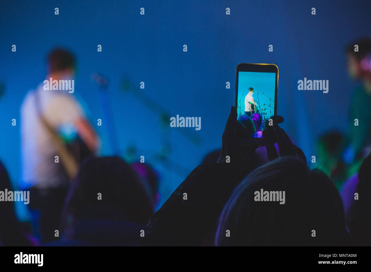 Rock concert. Girl is taking picture on phone camera at the concert of ...