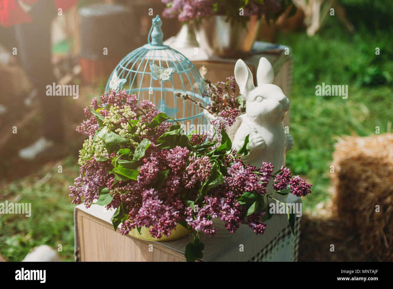 Easter atmosphere - rabbit, bouquet of lilac, willow, cage on sunset ...