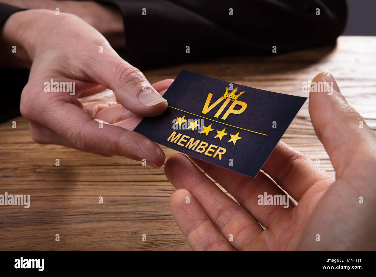 Close-up Of A Hand Giving Vip Card Over Wooden Desk Stock Photo - Alamy