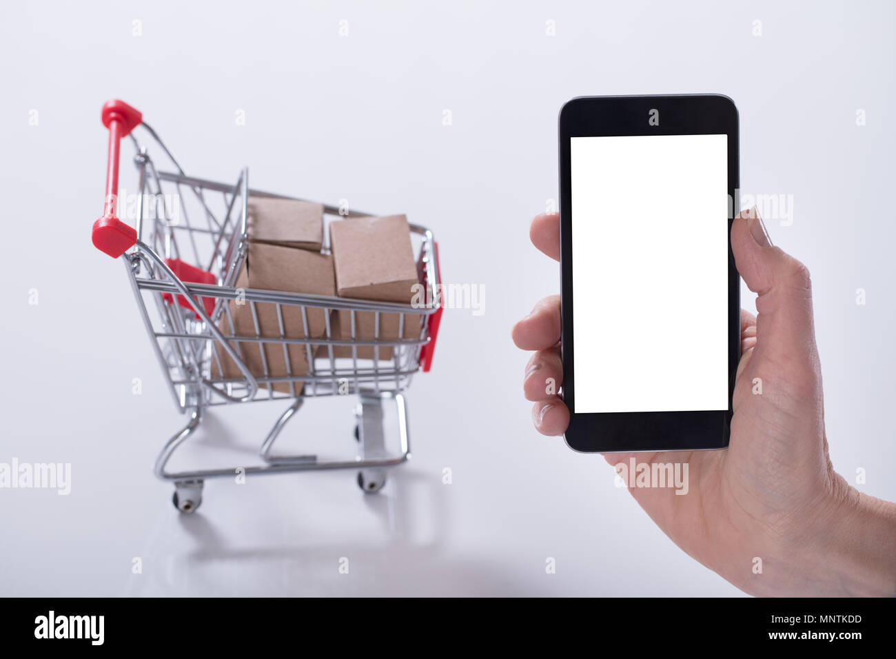 A Person Hand Showing Mobile Phone With Blank Screen And Shopping Cart ...
