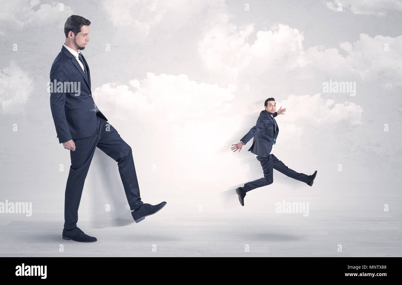 Big businessmen kicking himself as a small employee with cloudy ...