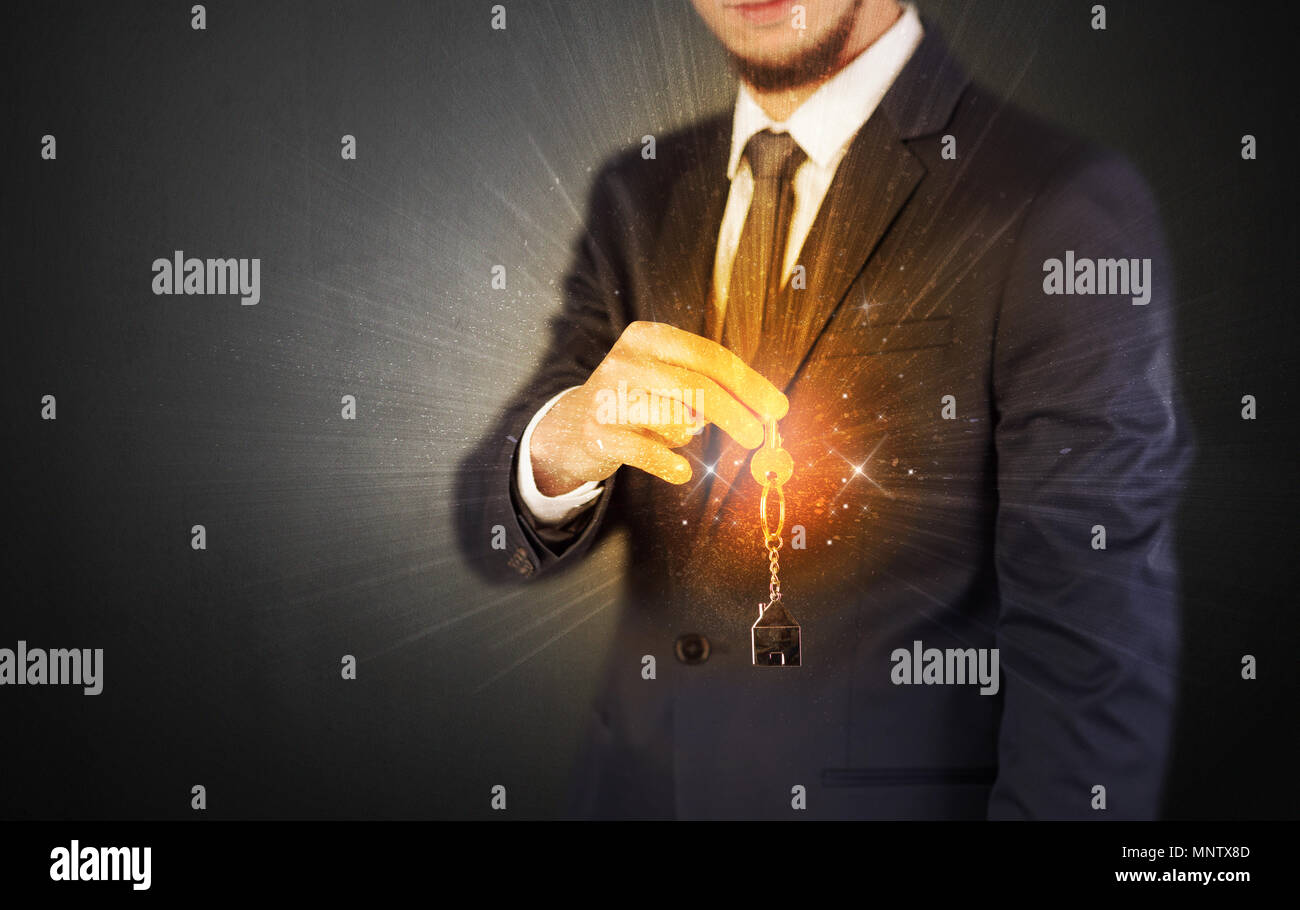 Formal man hand over shiny keys with dark background Stock Photo - Alamy