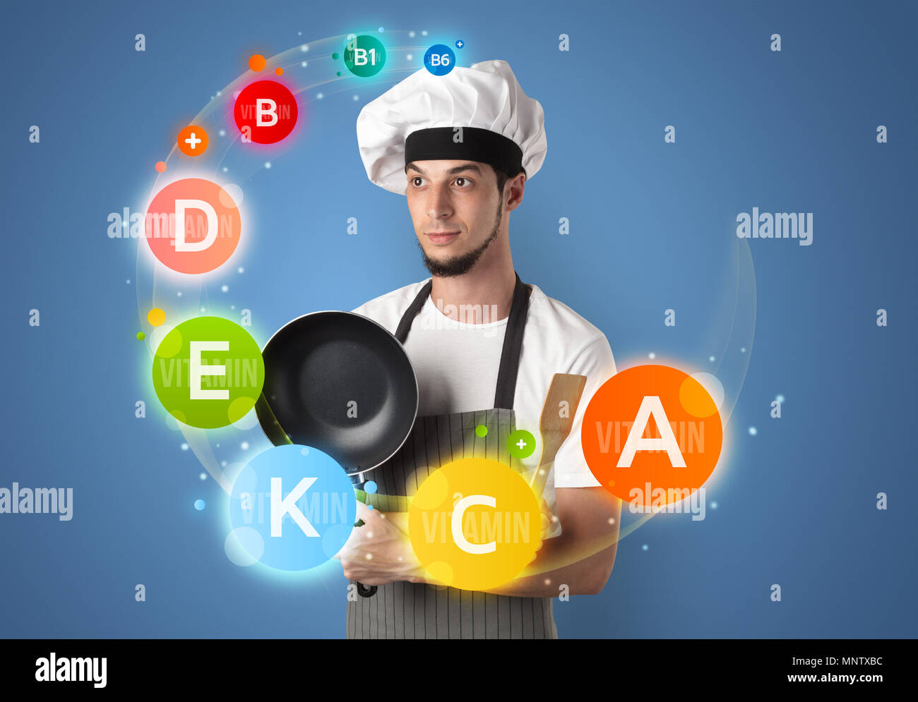 Handsome cook with kitchen instruments and vitamin concept Stock Photo ...