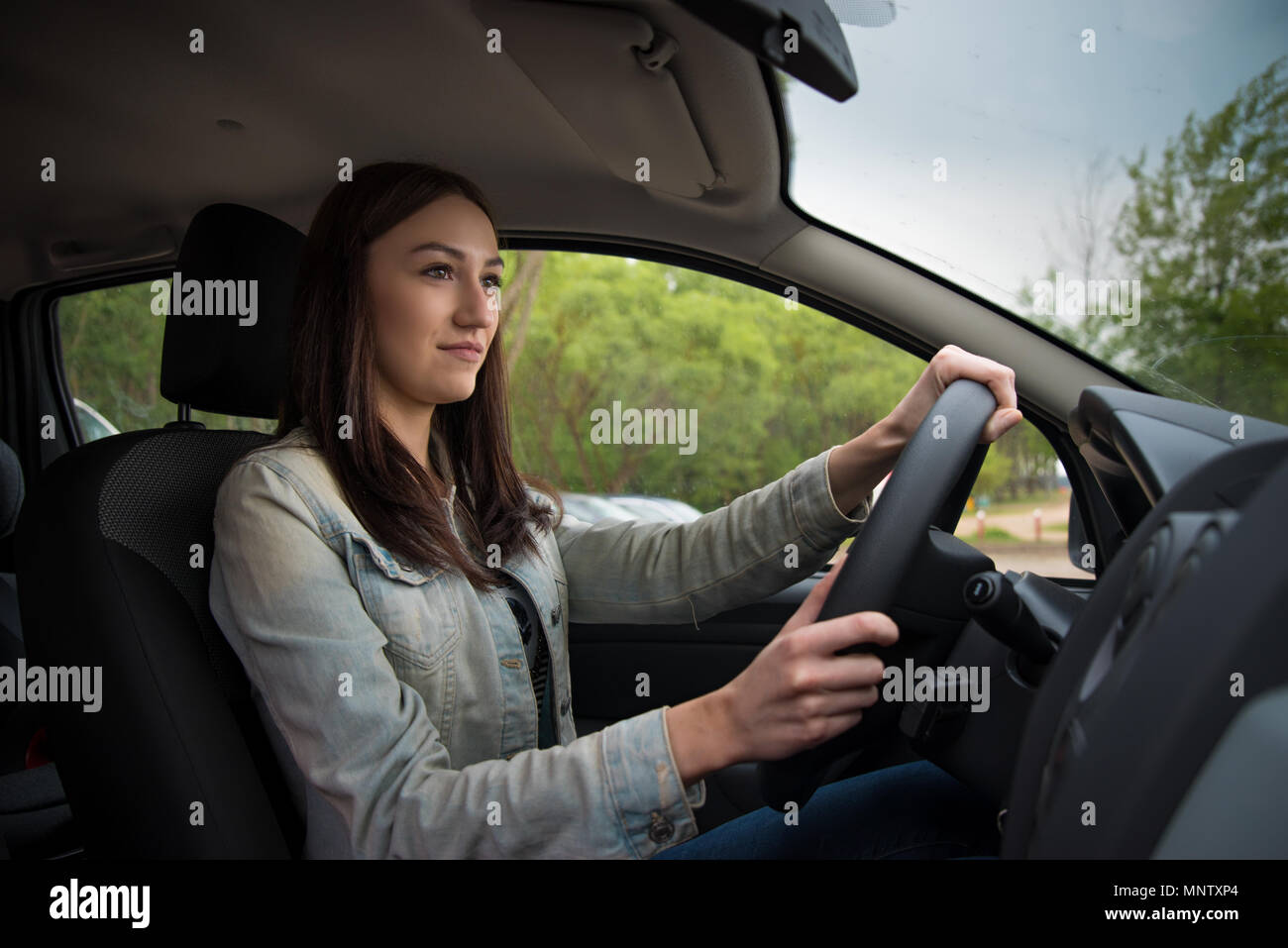 beautiful girl sits behind the wheel of a car Stock Photo - Alamy