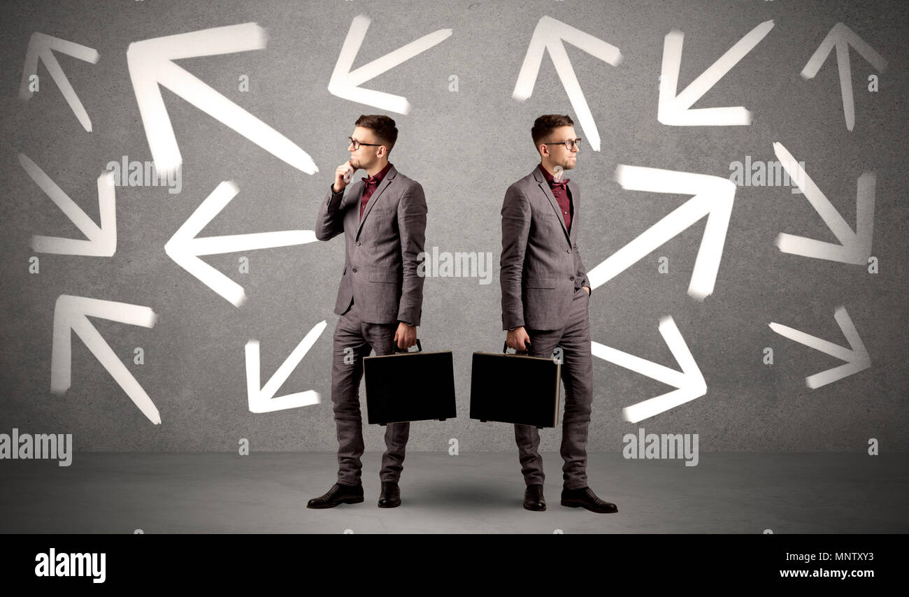 Young conflicted businessman choosing between two directions with ...