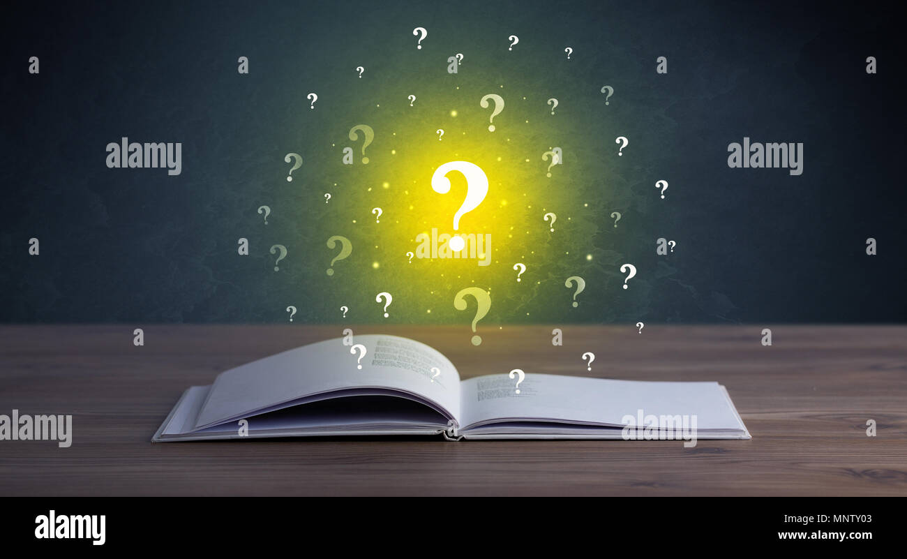 Yellow question marks hovering over open book Stock Photo - Alamy