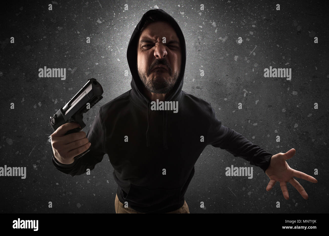 Masked armed villain in empty dark room with gun ax chainsaw mallet ...