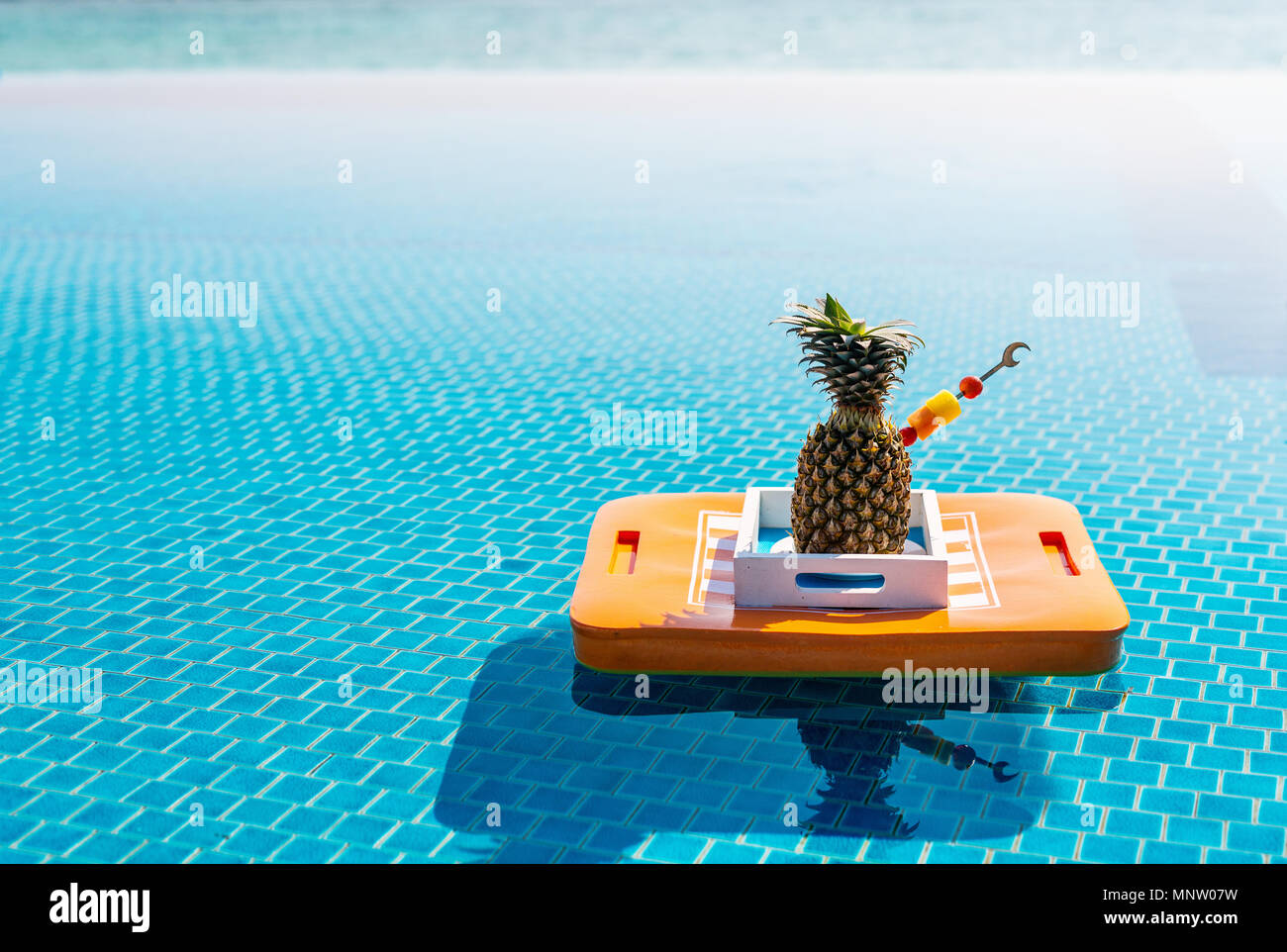Tropical cocktail in pineapple shell floating at pool Stock Photo - Alamy