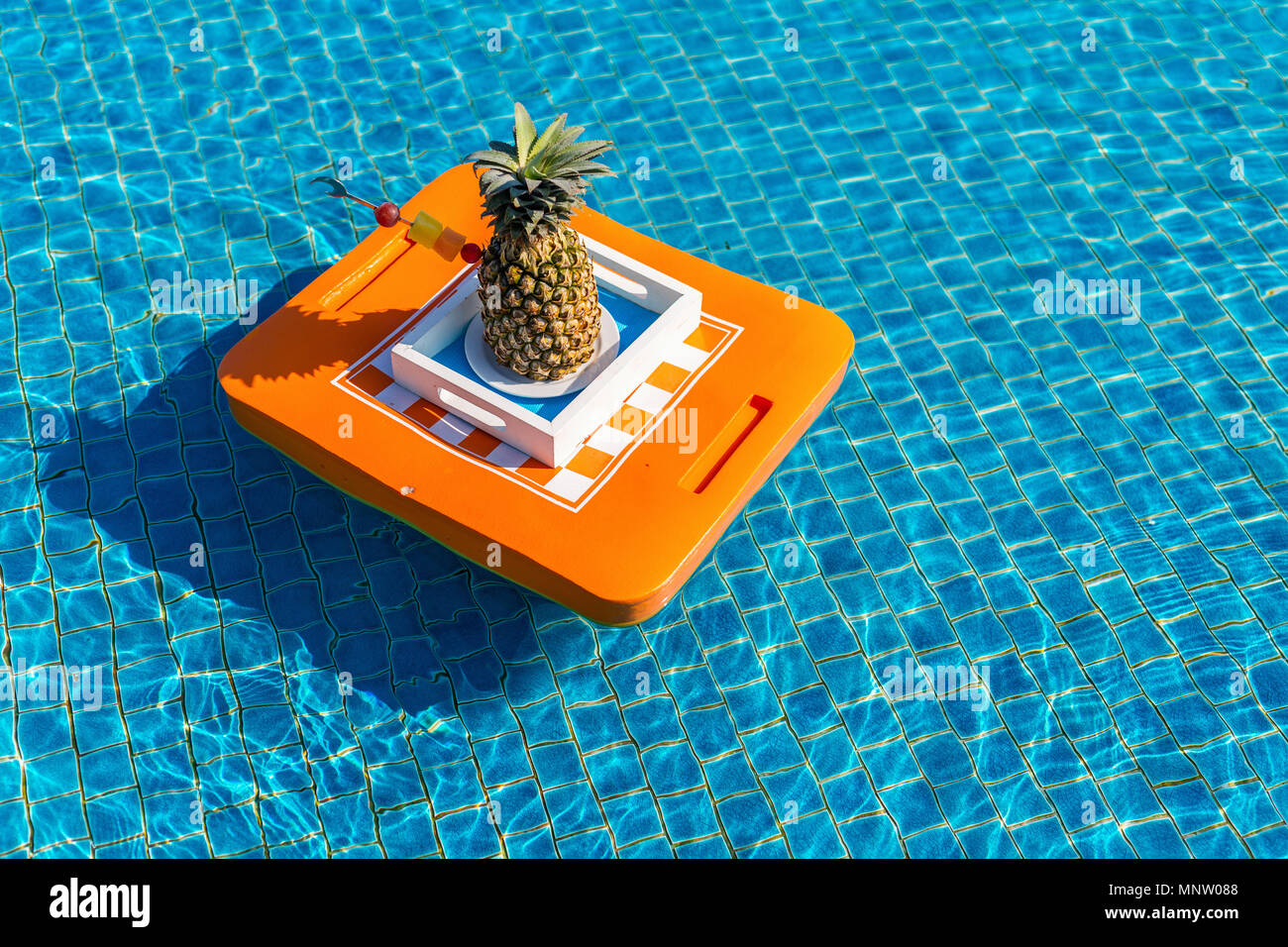 Tropical cocktail in pineapple shell floating at pool Stock Photo - Alamy